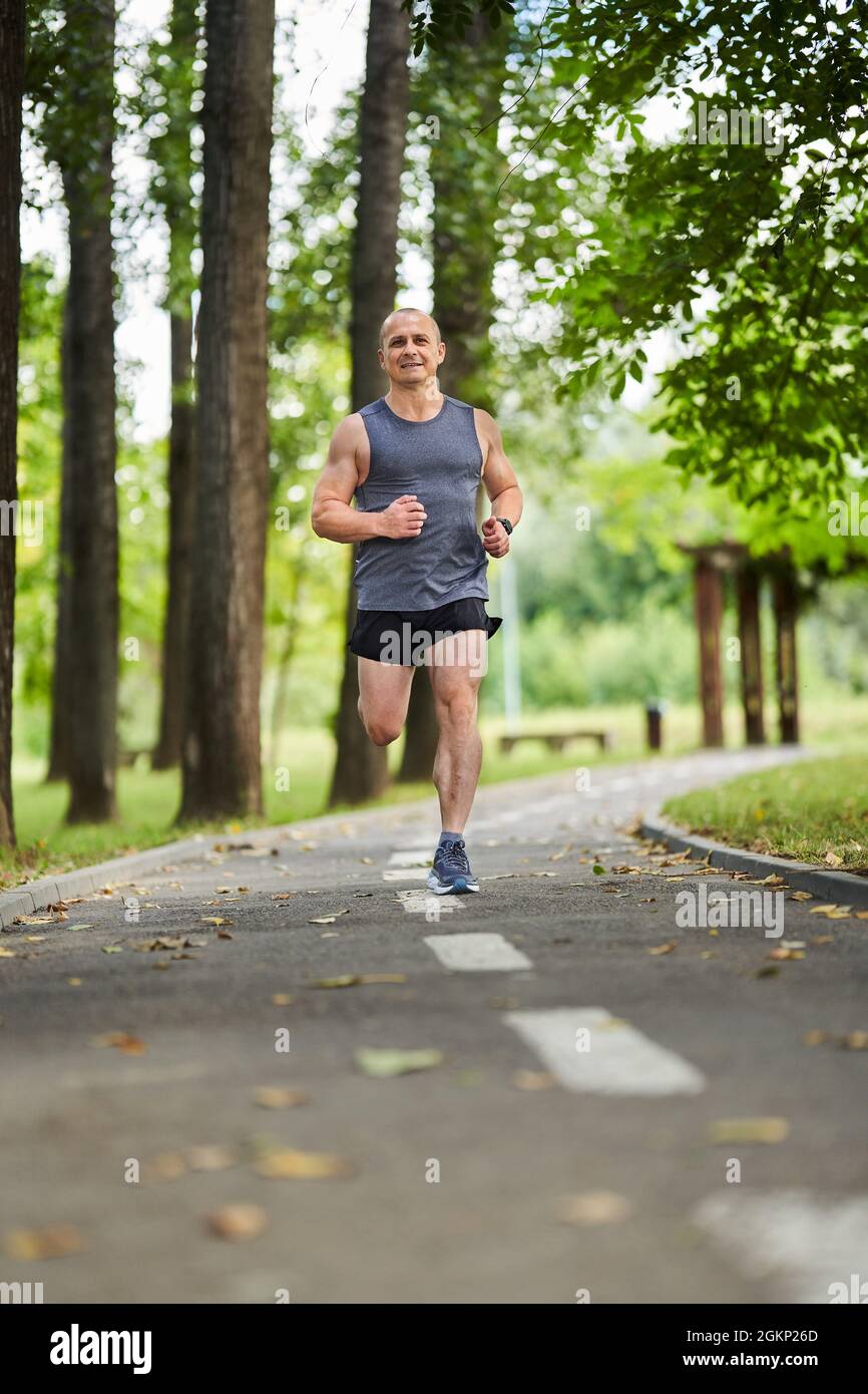 Athletic man marathon runner training in the park alleys Stock Photo ...
