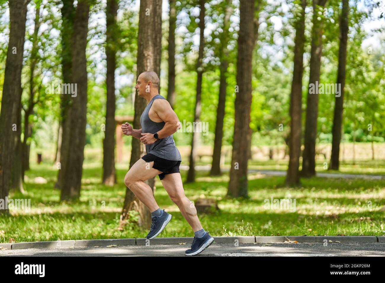 Athletic man marathon runner training in the park alleys Stock Photo ...