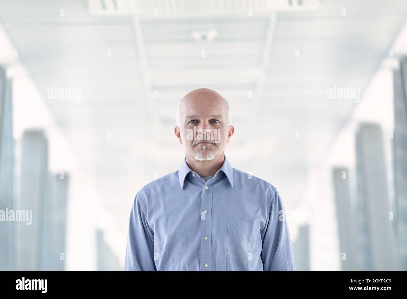Senior businessman with a deadpan serious expression approaching the ...