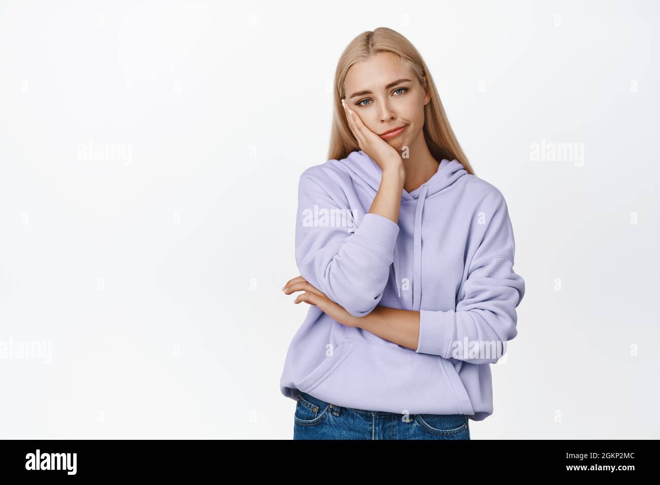 Sad and unamused blond woman smirking, looking at camera unimpressed ...