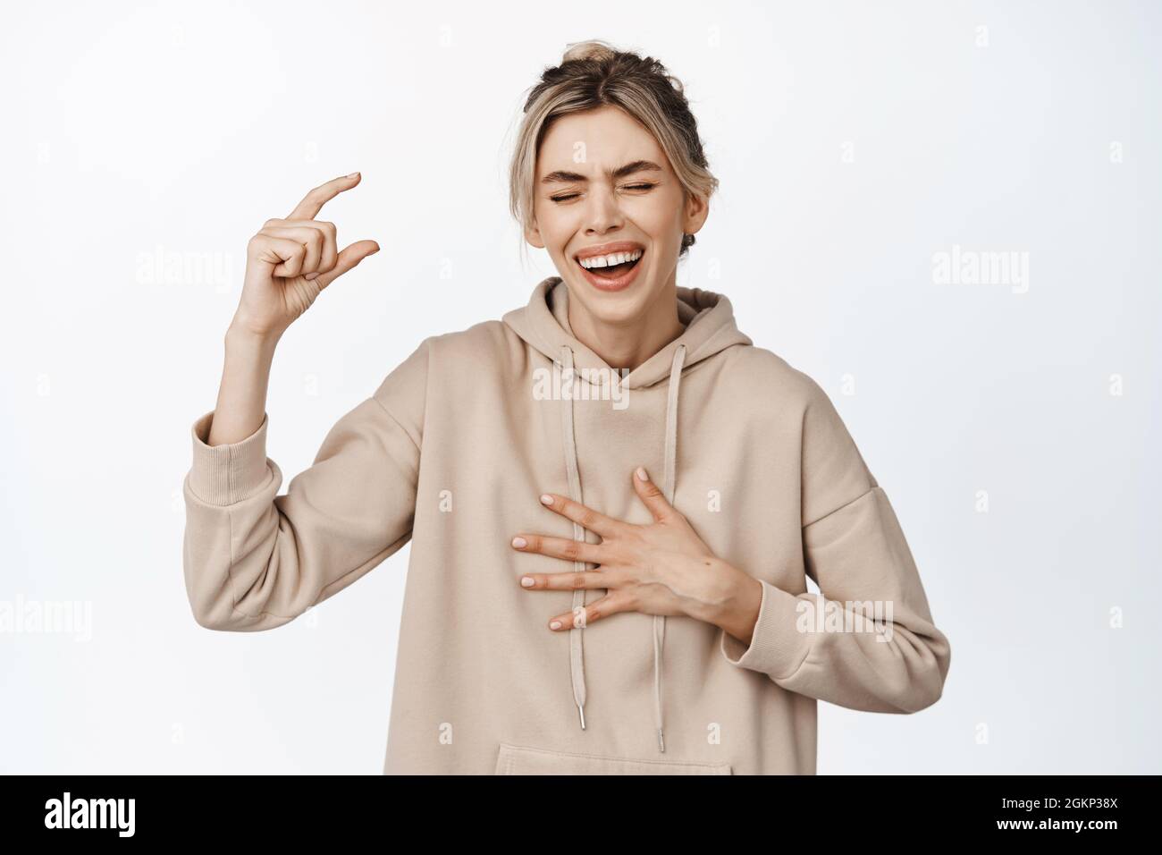 Image of young woman pinching fingers, holding something small or tiny ...