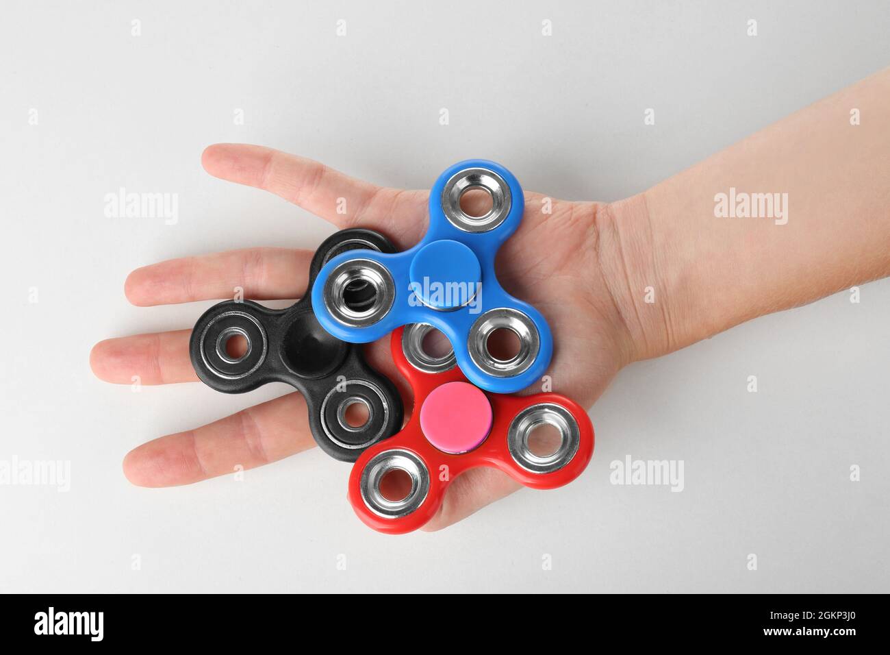 Man holding modern spinners on white background Stock Photo - Alamy