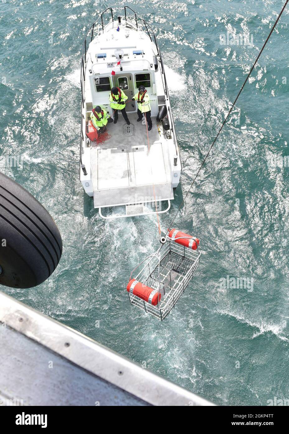 Boat crew members from the Ontario Provincial Police tend the trail ...