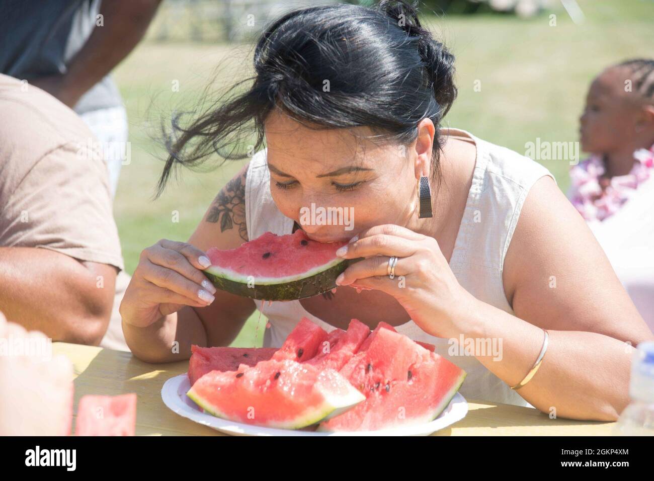 A family member participates in a watermelon eating contest at the Navy ...
