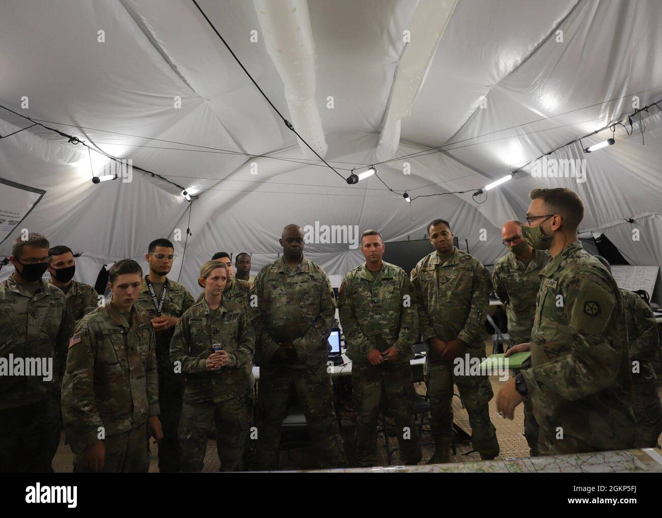 A group of V Corps Soldiers conduct a shift change brief during the ...