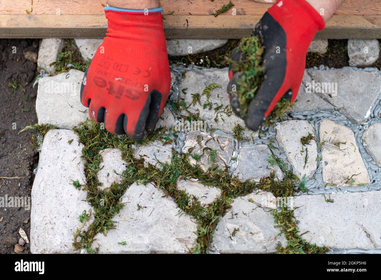 A gardener lays moss on a pathway at the James Doran-Webb Driftwood ...