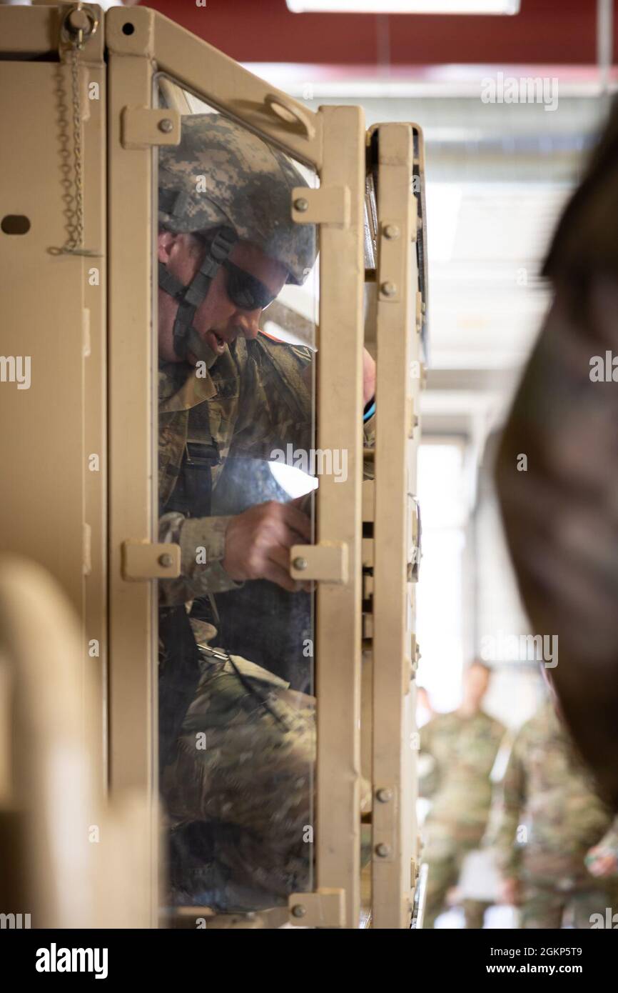 A Soldier opens an exit hatch in a vehicle rollover simulator while ...