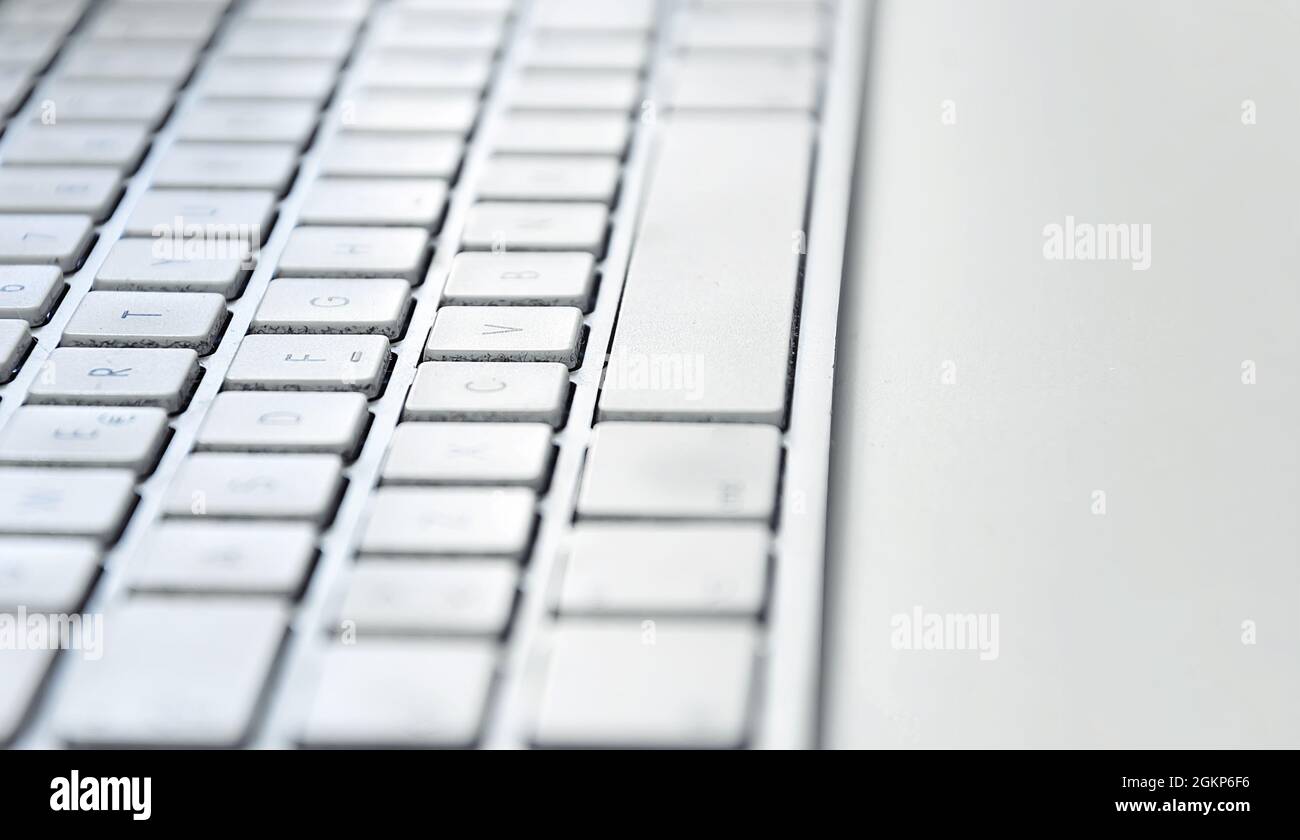 Detail of a modern white computer keyboard dirty and dusty on a white ...