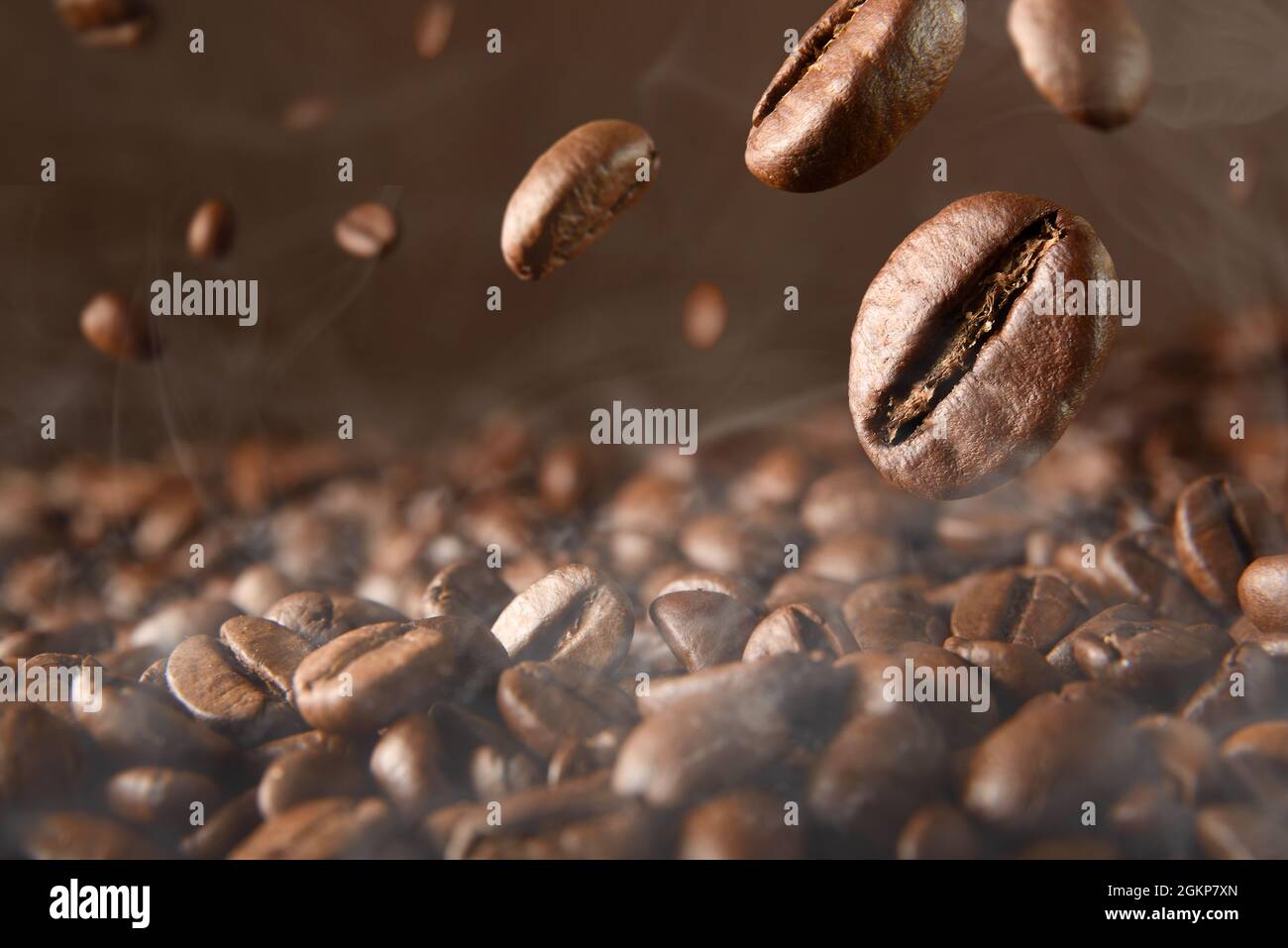 Roasted hot coffee beans falling on pile of coffee beans. Front view ...