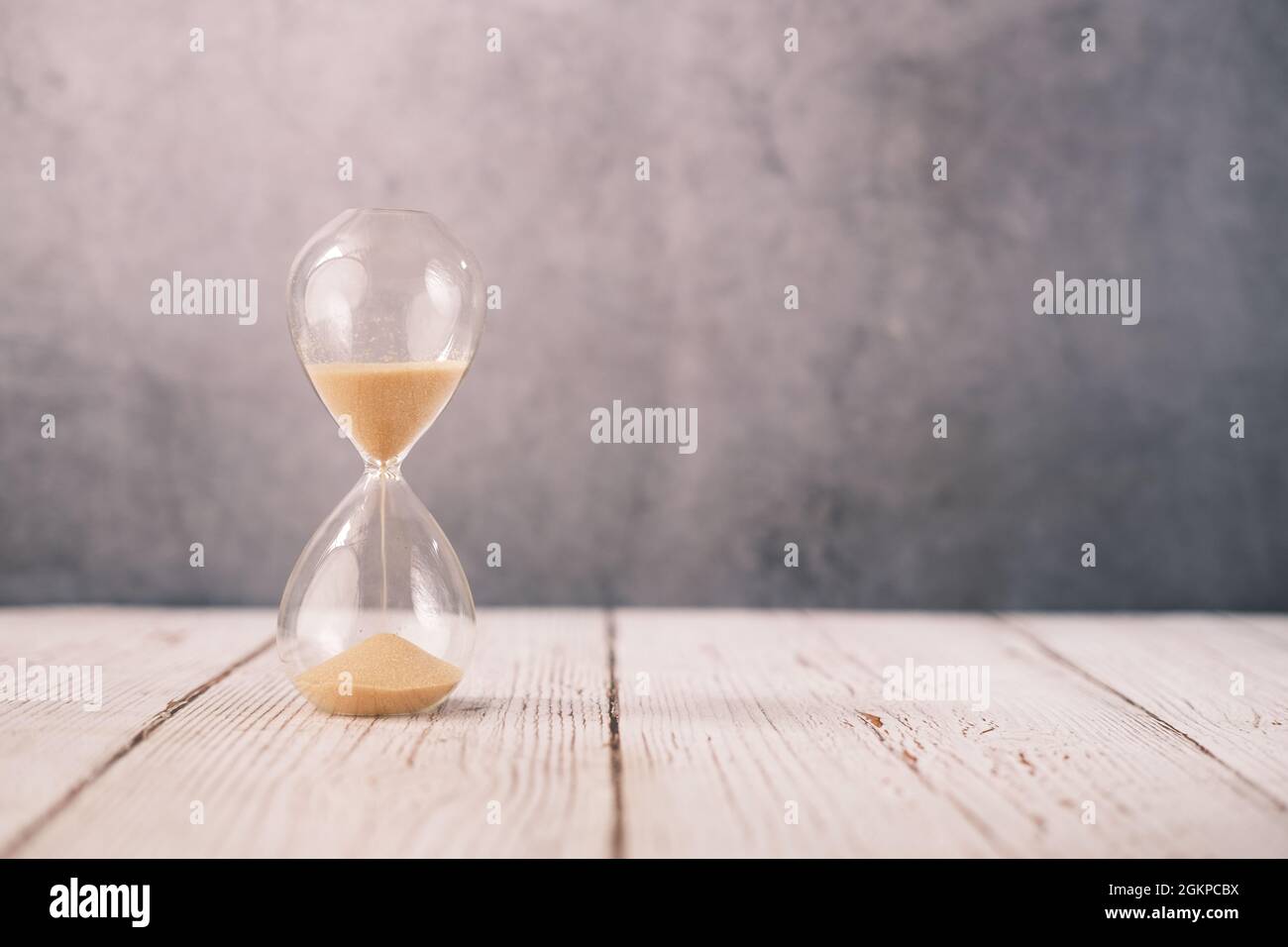 hourglass on table, sand flowing through the bulb of sandglass Stock ...