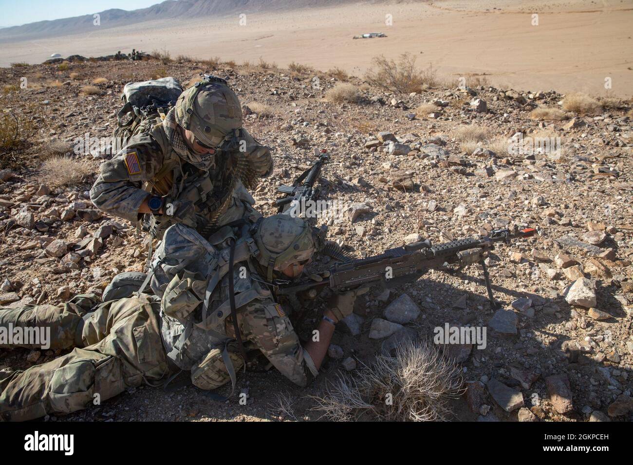 Spc. Michael Geiling assists Spc. Trent Baker, both infantrymen with ...