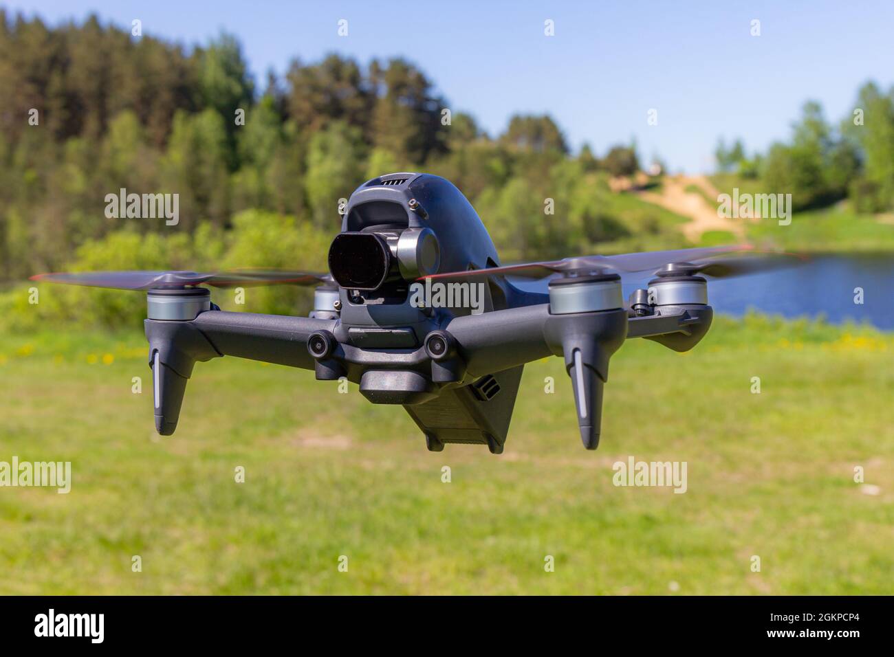 New FPV drone is flying during a sunny day on grass in beckground. Top ...