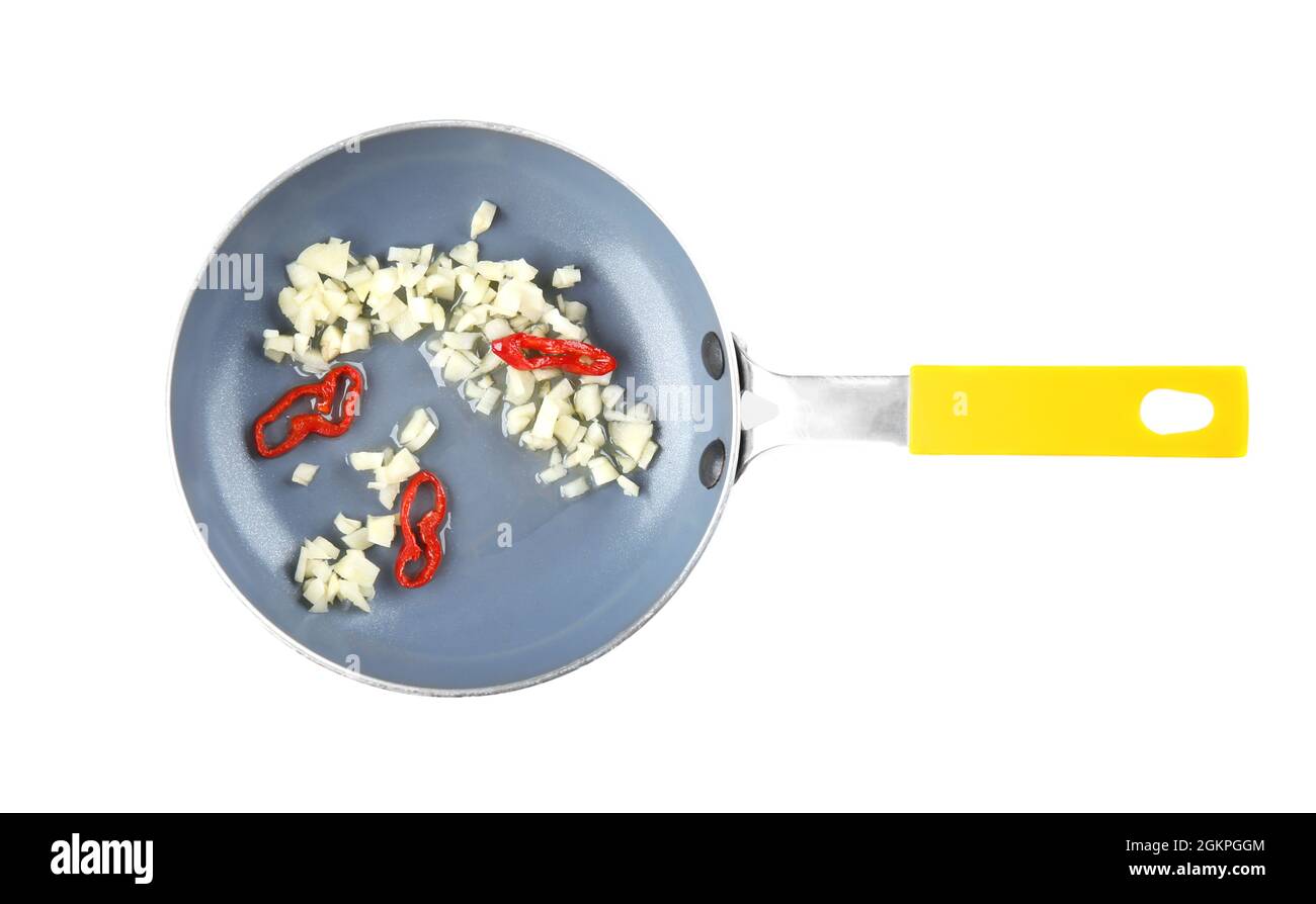 Frying pan with cooking oil, chopped garlic and chili on white ...