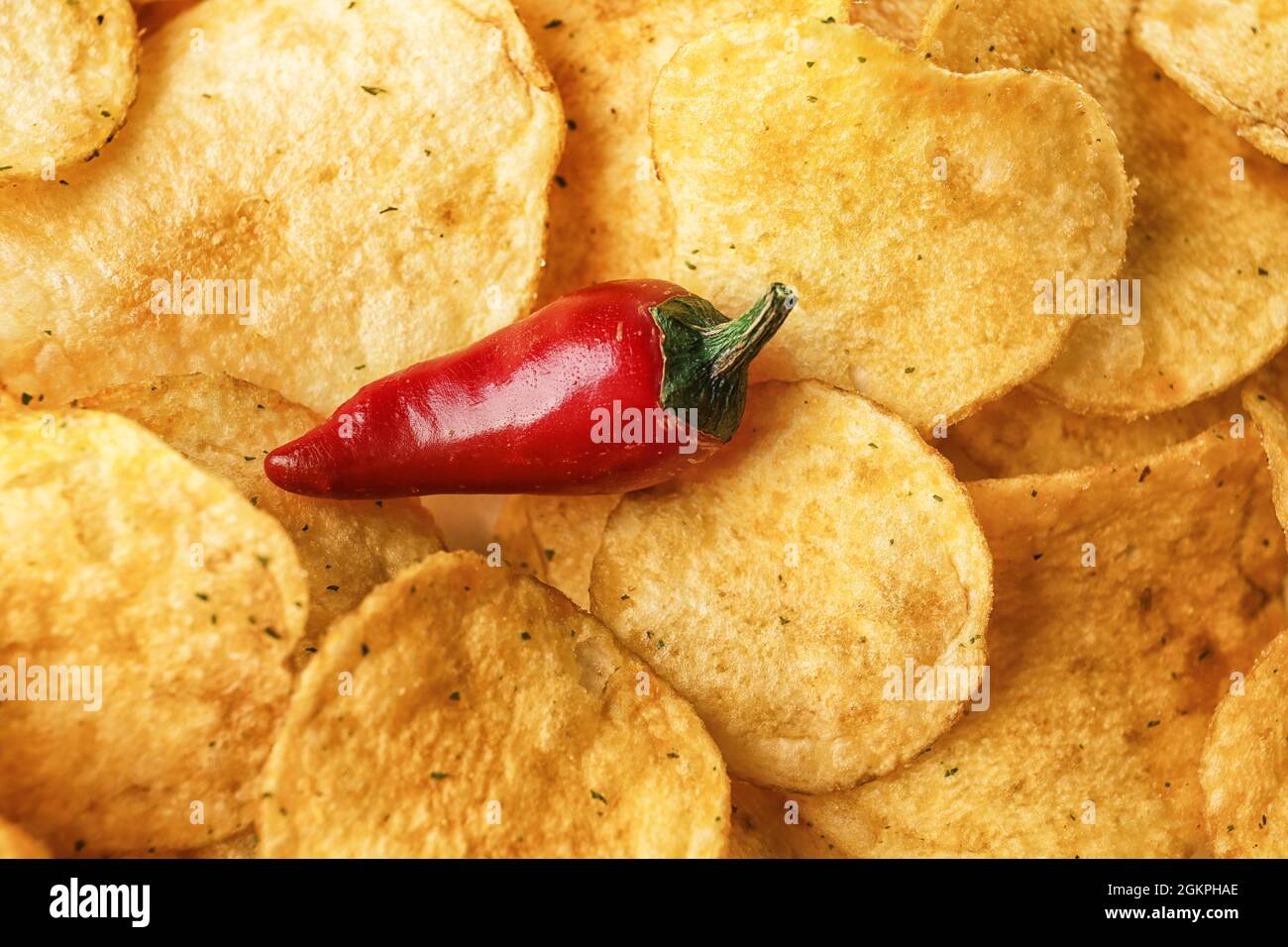 Potato chips with chili pepper as background Stock Photo - Alamy