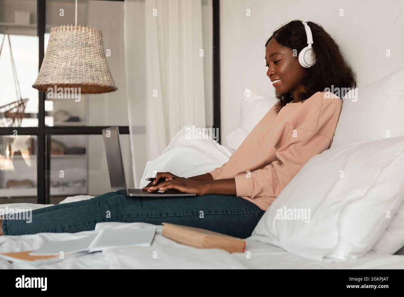 Side-View Of Black Woman Using Laptop Learning Online In Bedroom Stock ...