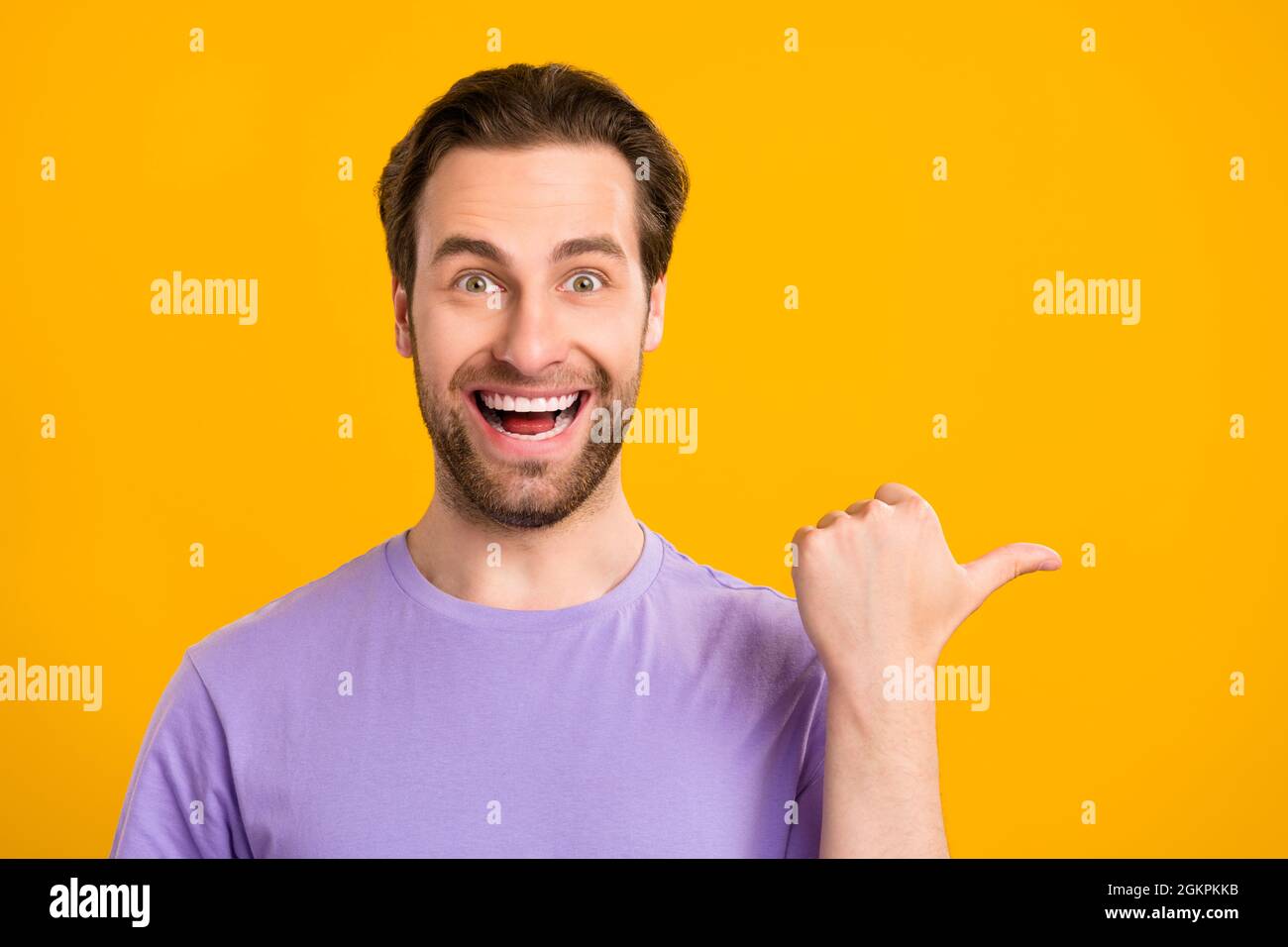 Photo of impressed funny young gentleman wear violet t-shirt pointing ...