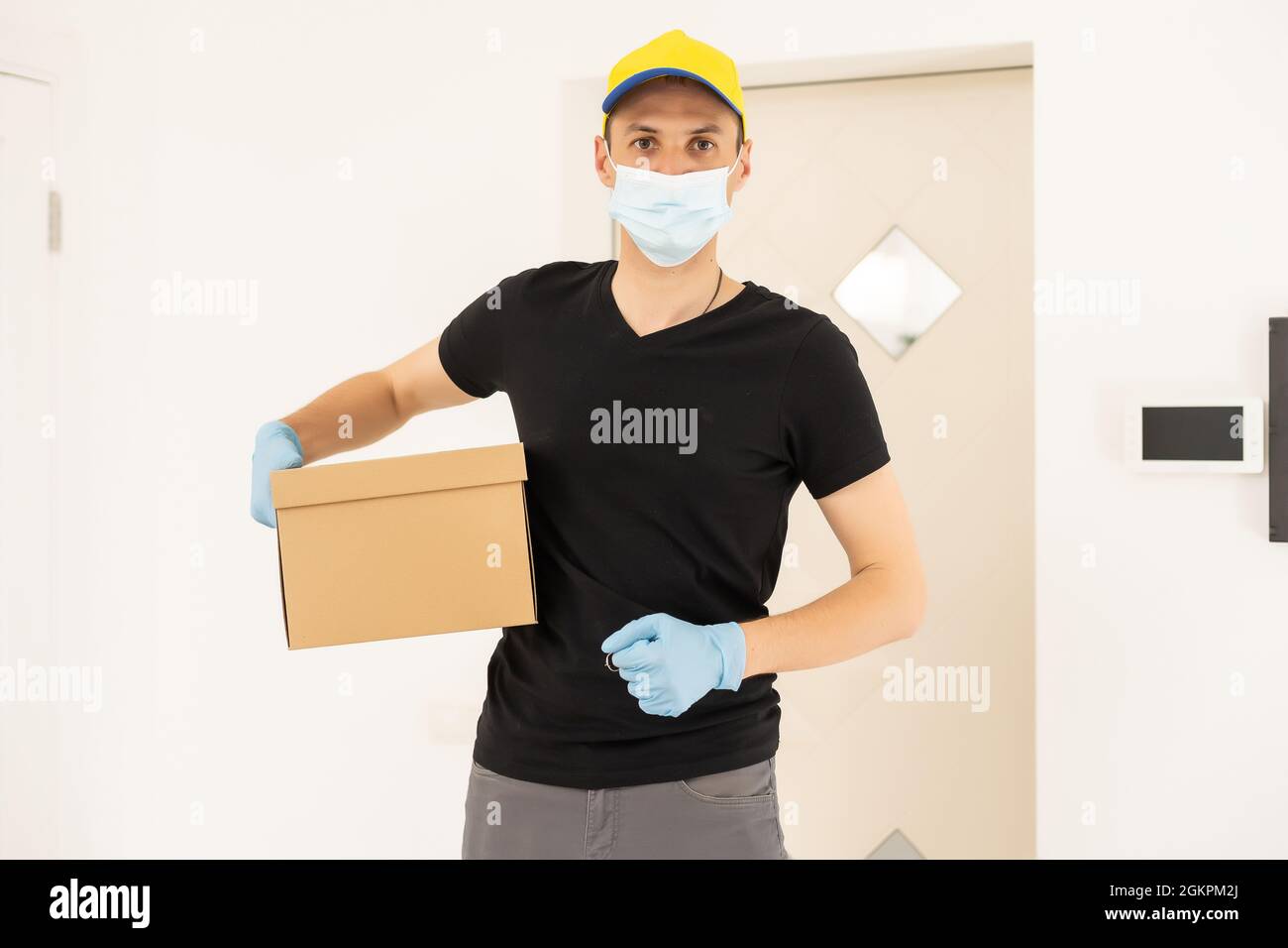 delivery man holding package to deliver. Courier hand holding brown box ...