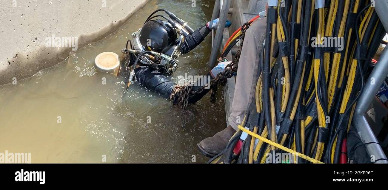 A contract diver enters the water at Pine Creek Lake Dam in ...