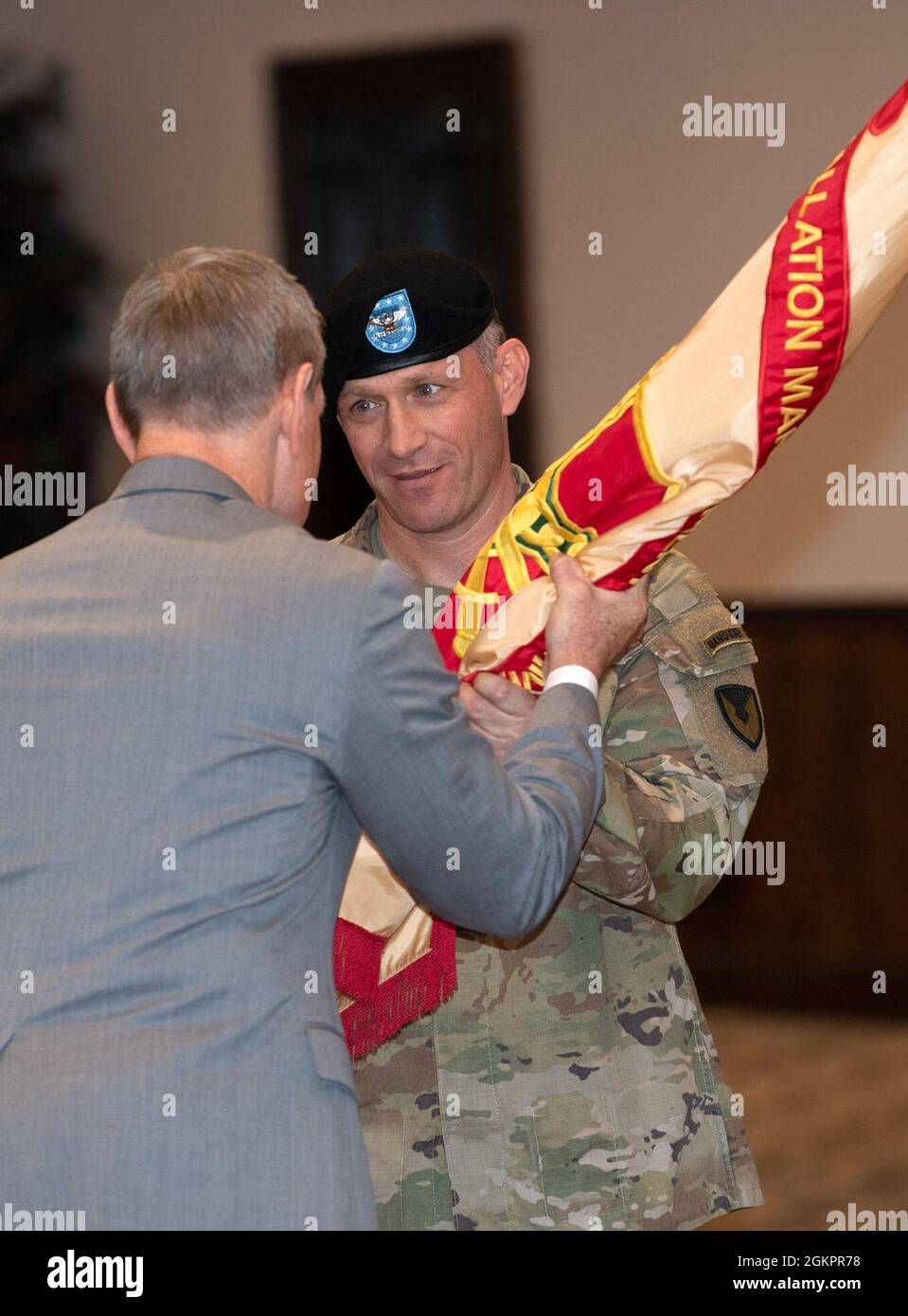Col. Ryan Hanson, garrison commander, takes the unit colors from Mr ...