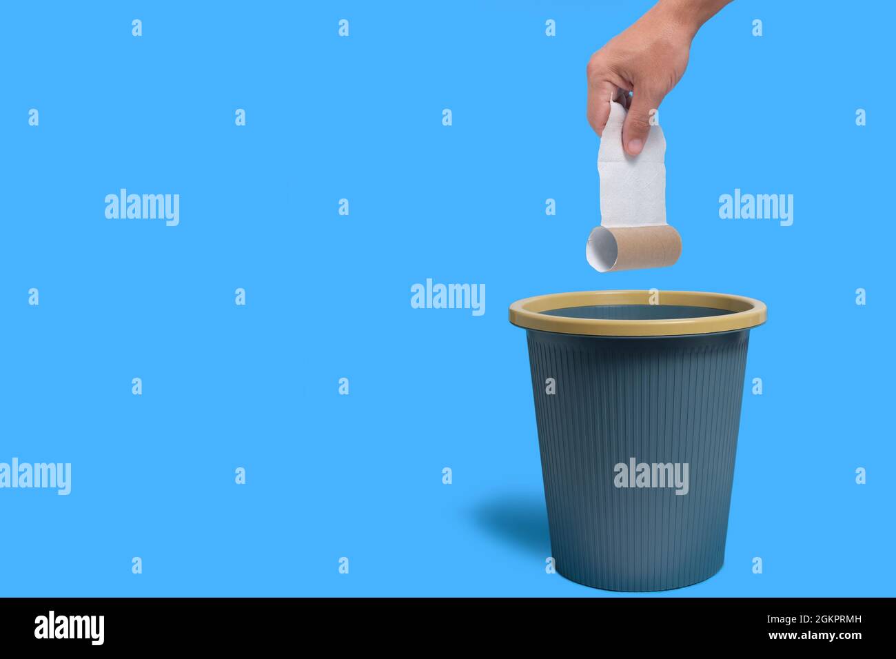 Spent roll of toilet paper thrown into trash, on a blue background ...