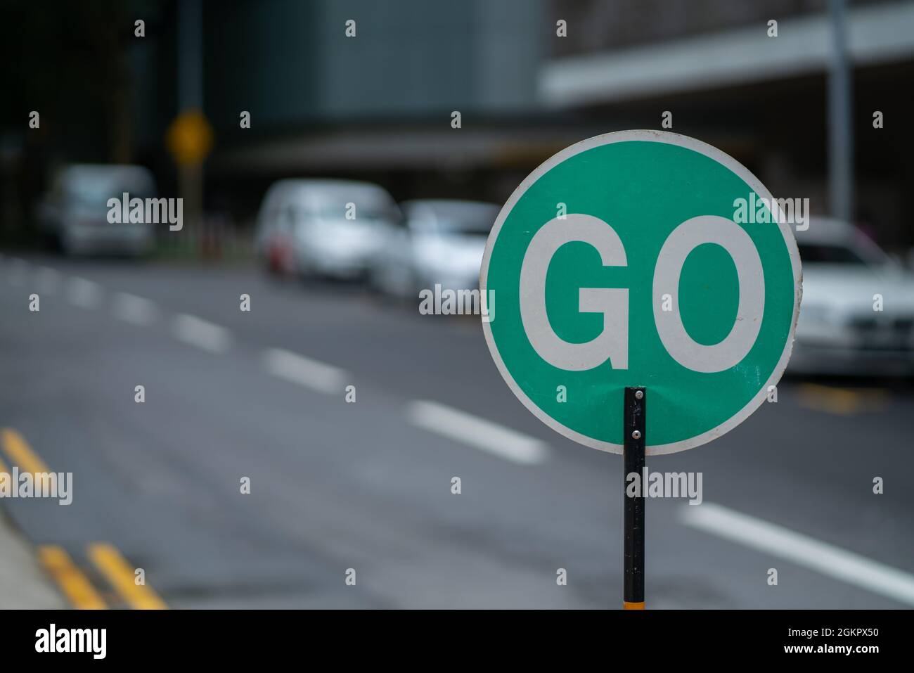Closeup of a green go sign on the road with blurred background Stock Photo - Alamy