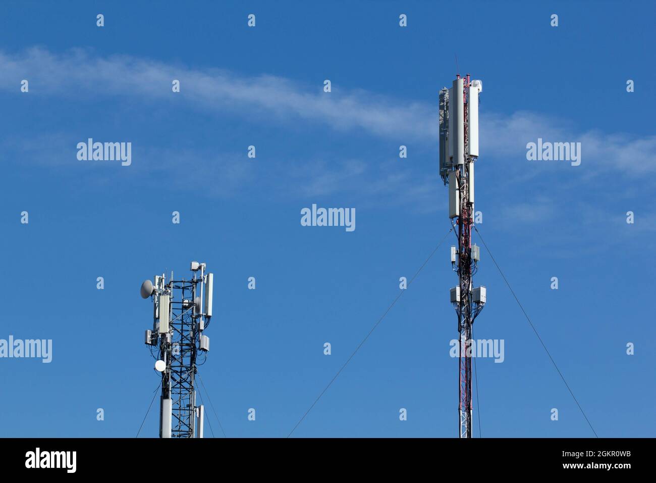 Mobile cell phone tower against the background of a blue sky and white cloud. Telecommunication ...