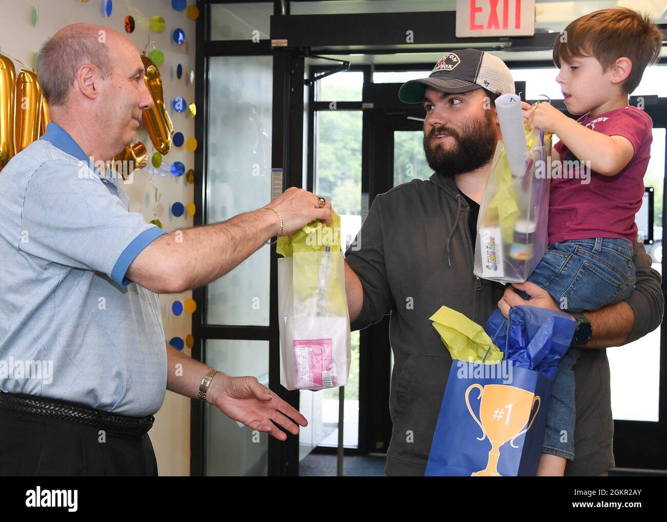 Paul Daddario, an Airman and Family Readiness Center volunteer, hands a ...