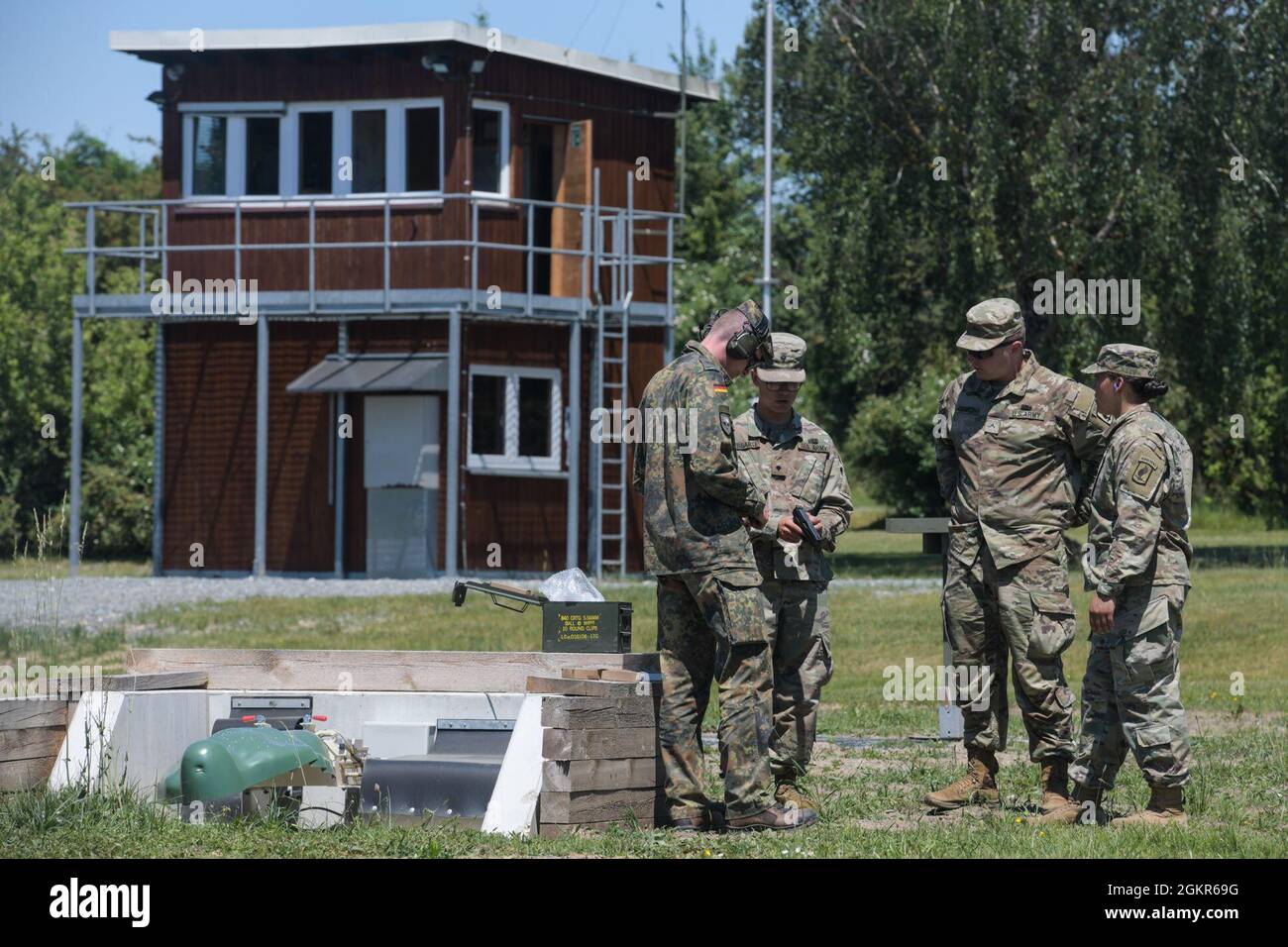 A German Army soldier, left, briefs U.S. Army paratroopers, assigned to ...