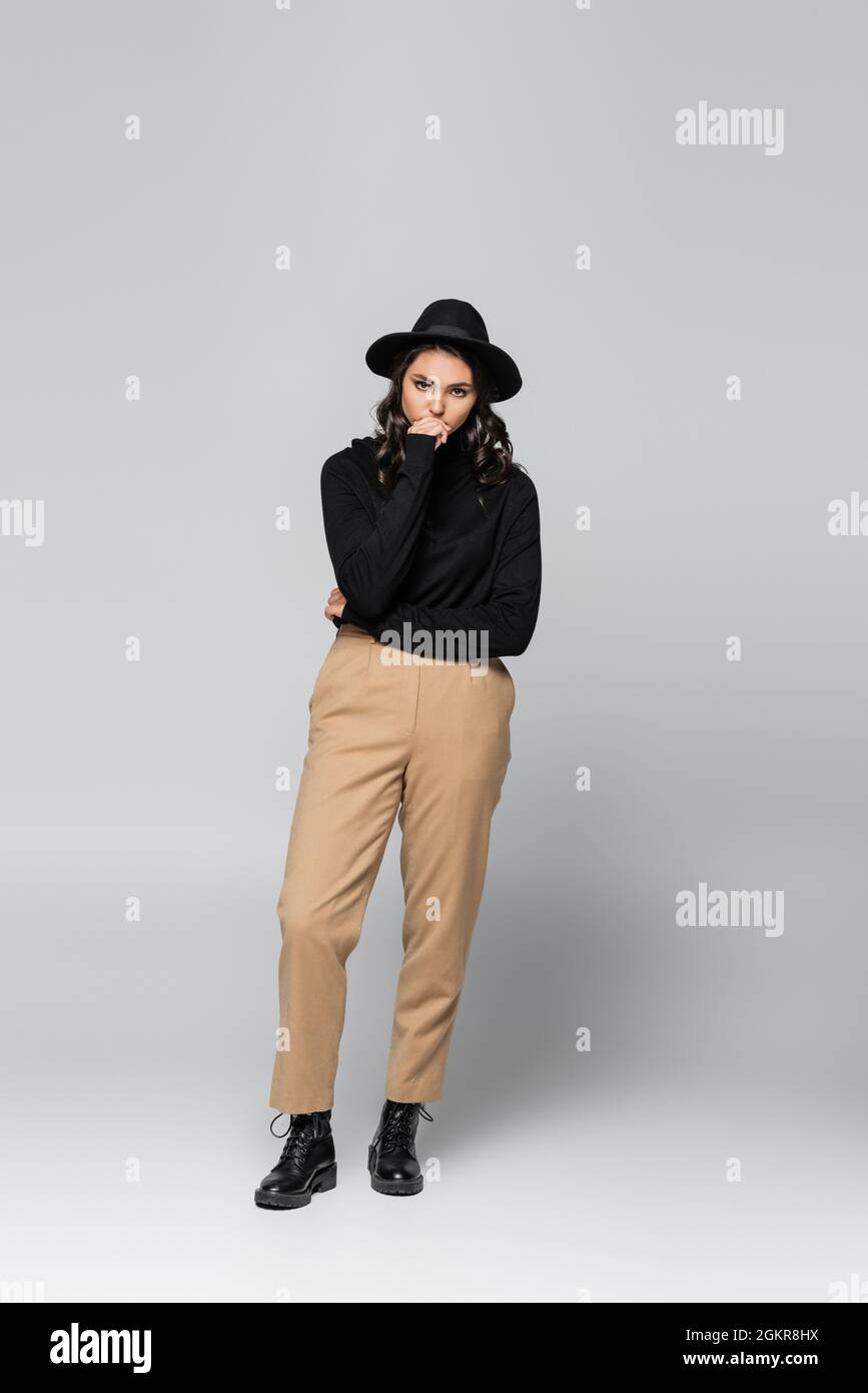 full length of young model in black fedora hat and stylish outfit ...