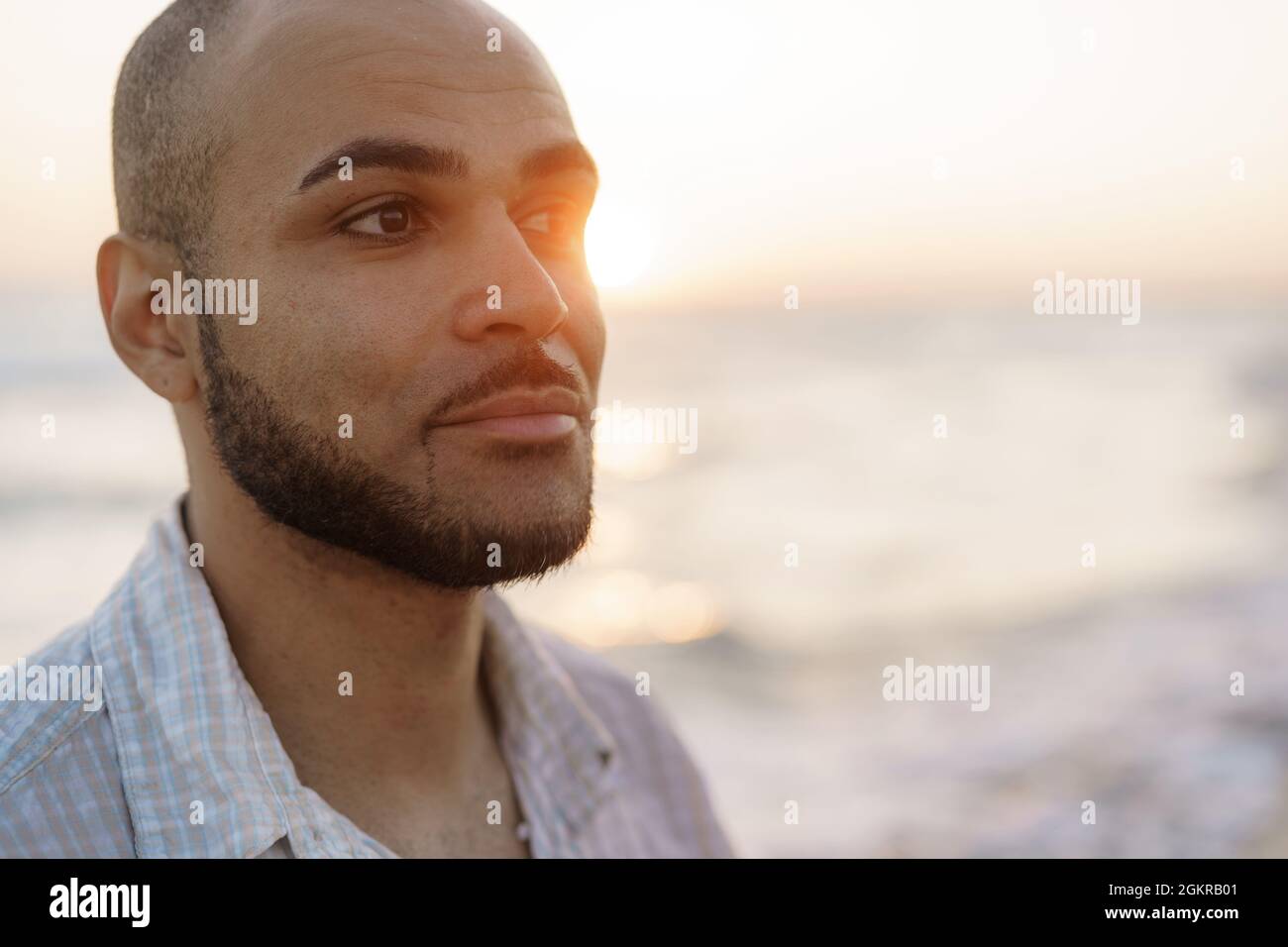 Portrait of a handsome young american man during sunset at the beach ...