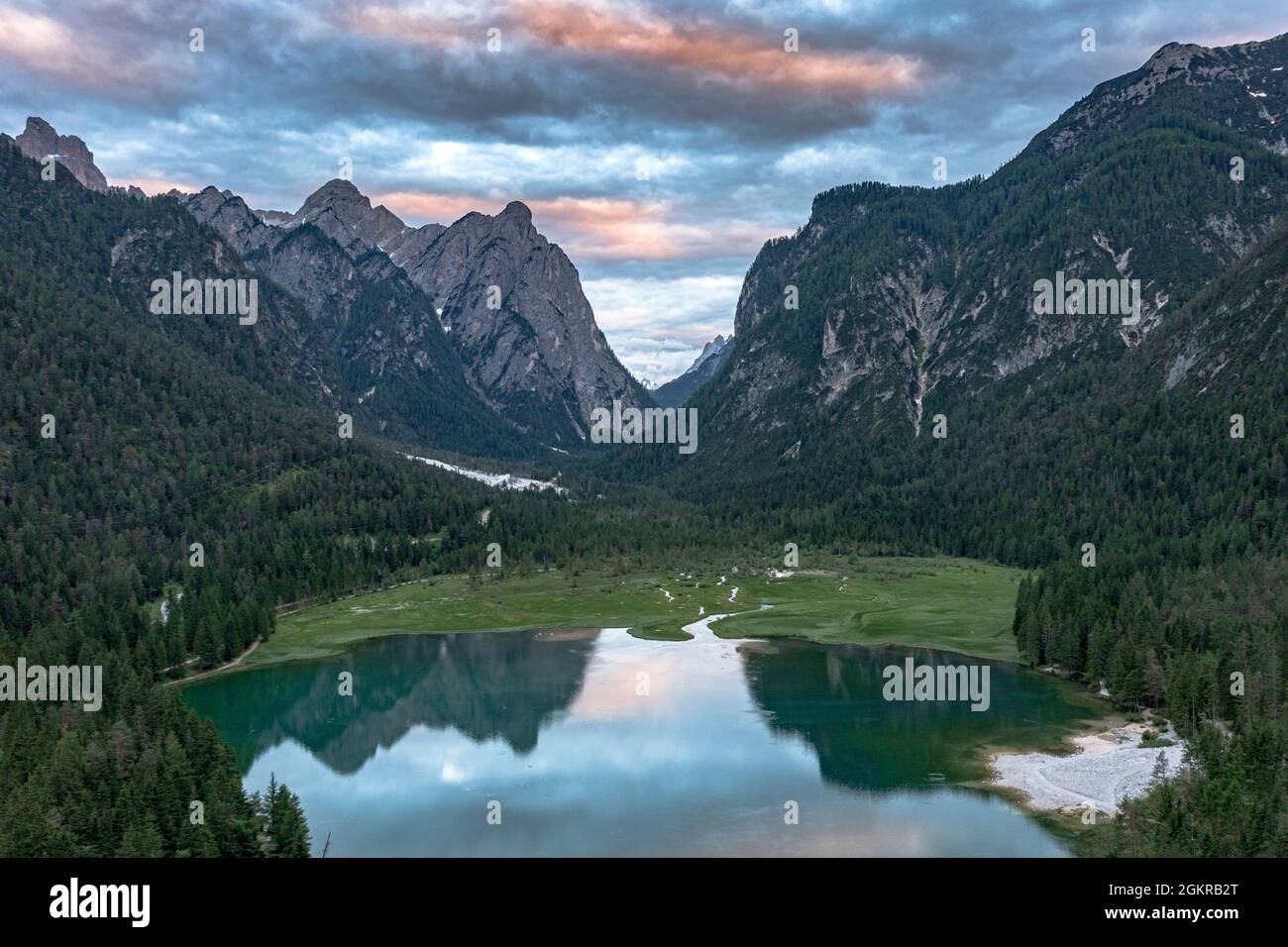 Aerial view of mountains reflected in lake Dobbiaco at sunset, Dobbiaco ...
