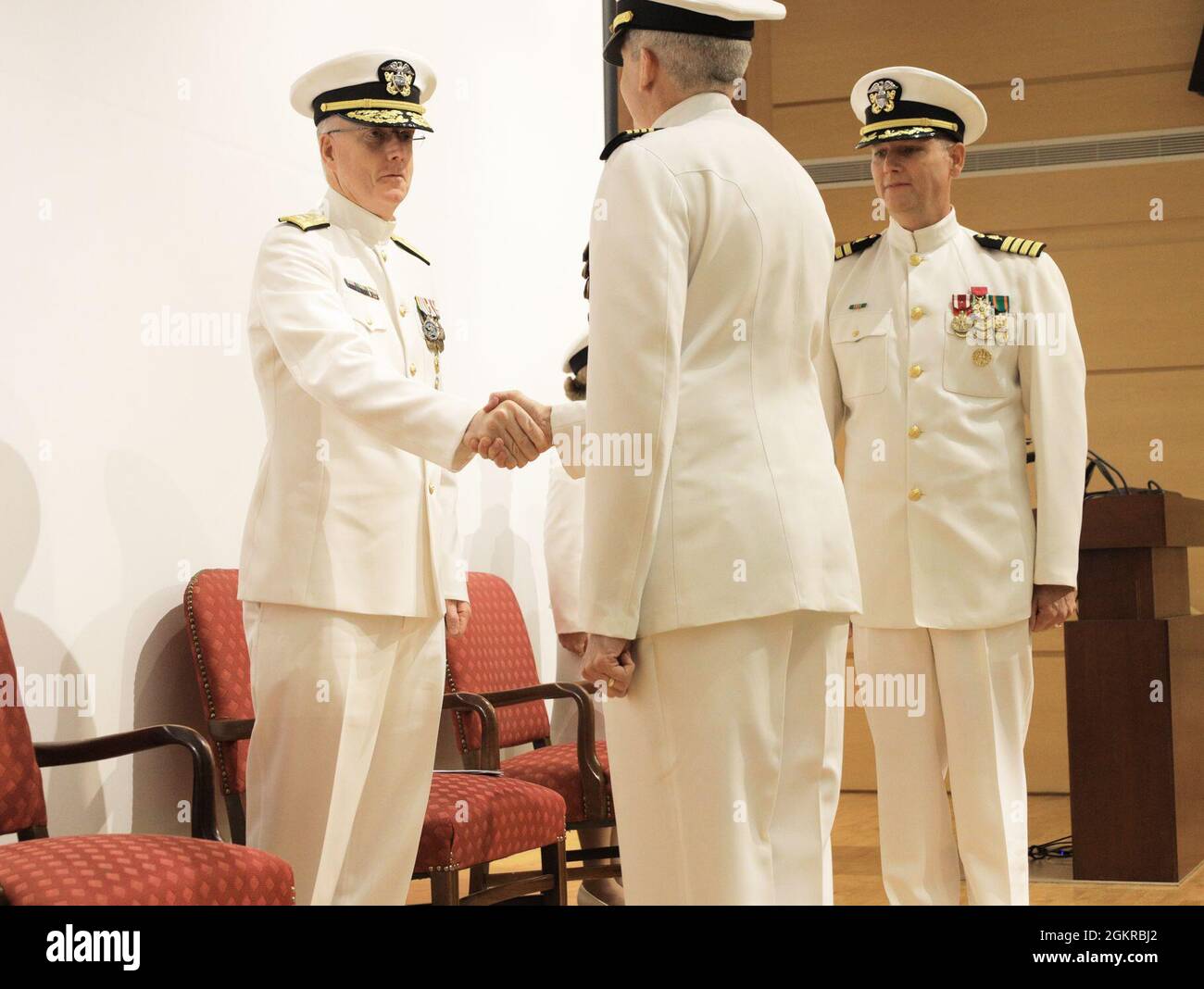 Rear Adm. Tim Weber, commander, Naval Medical Forces Pacific, shakes hands with Capt. Adam ...
