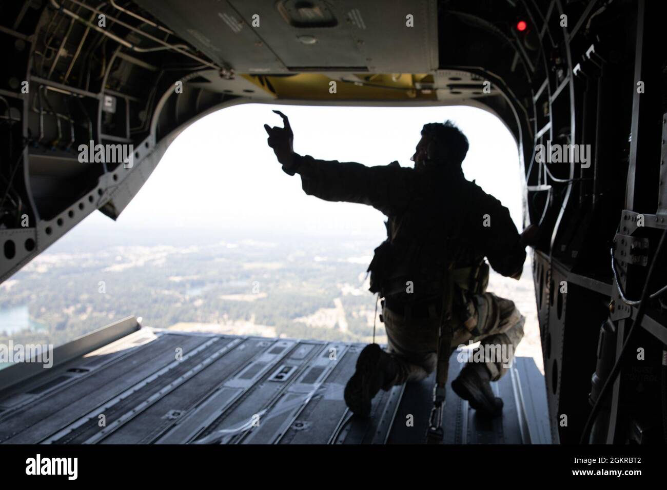 A CH-47 Chinook crewmember issues hand signals to Rangers preparing to ...