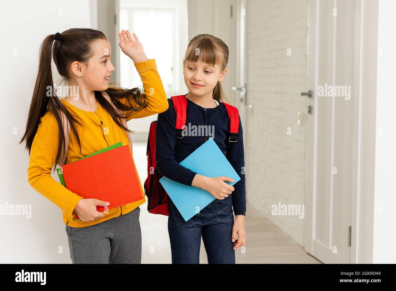 two pretty young schoolgirls. girls carry notebooks Stock Photo - Alamy