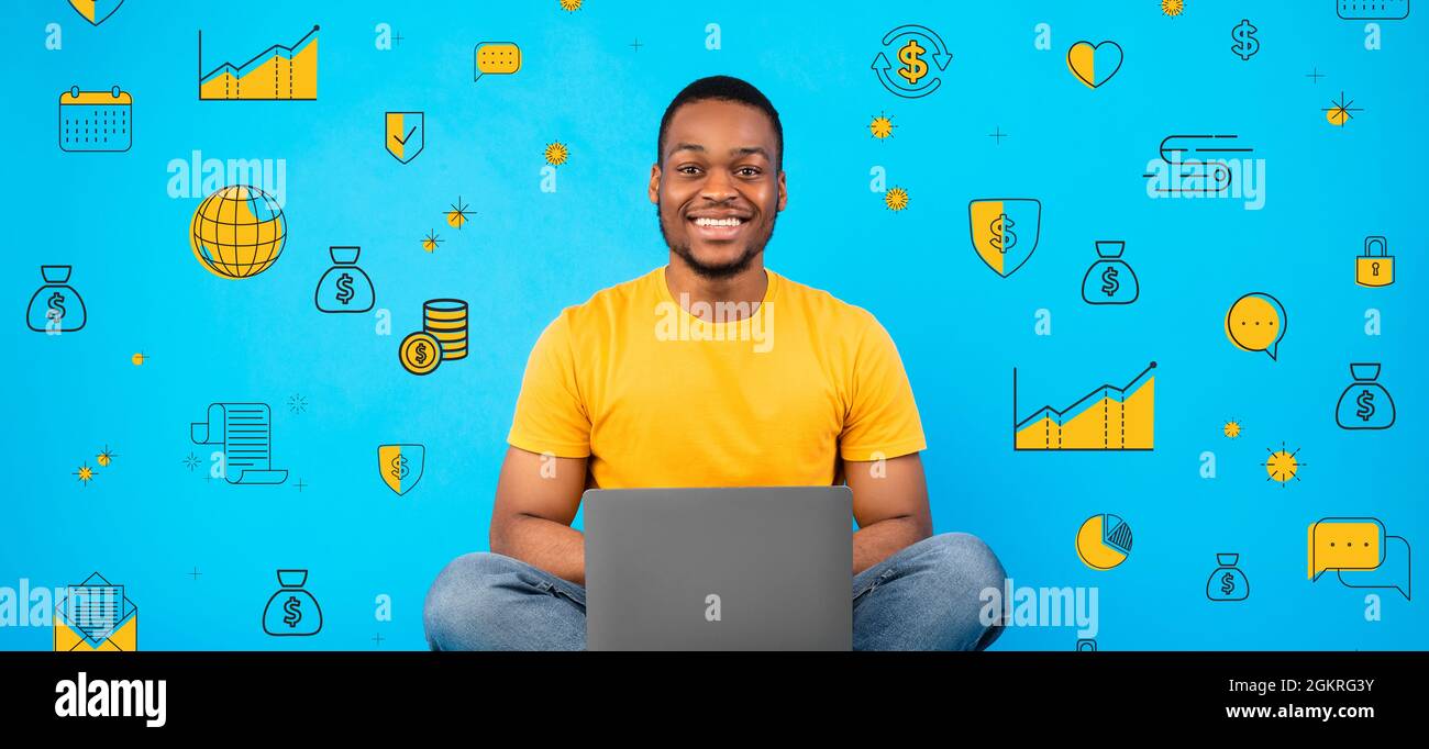 Happy African American guy using laptop computer on blue background ...