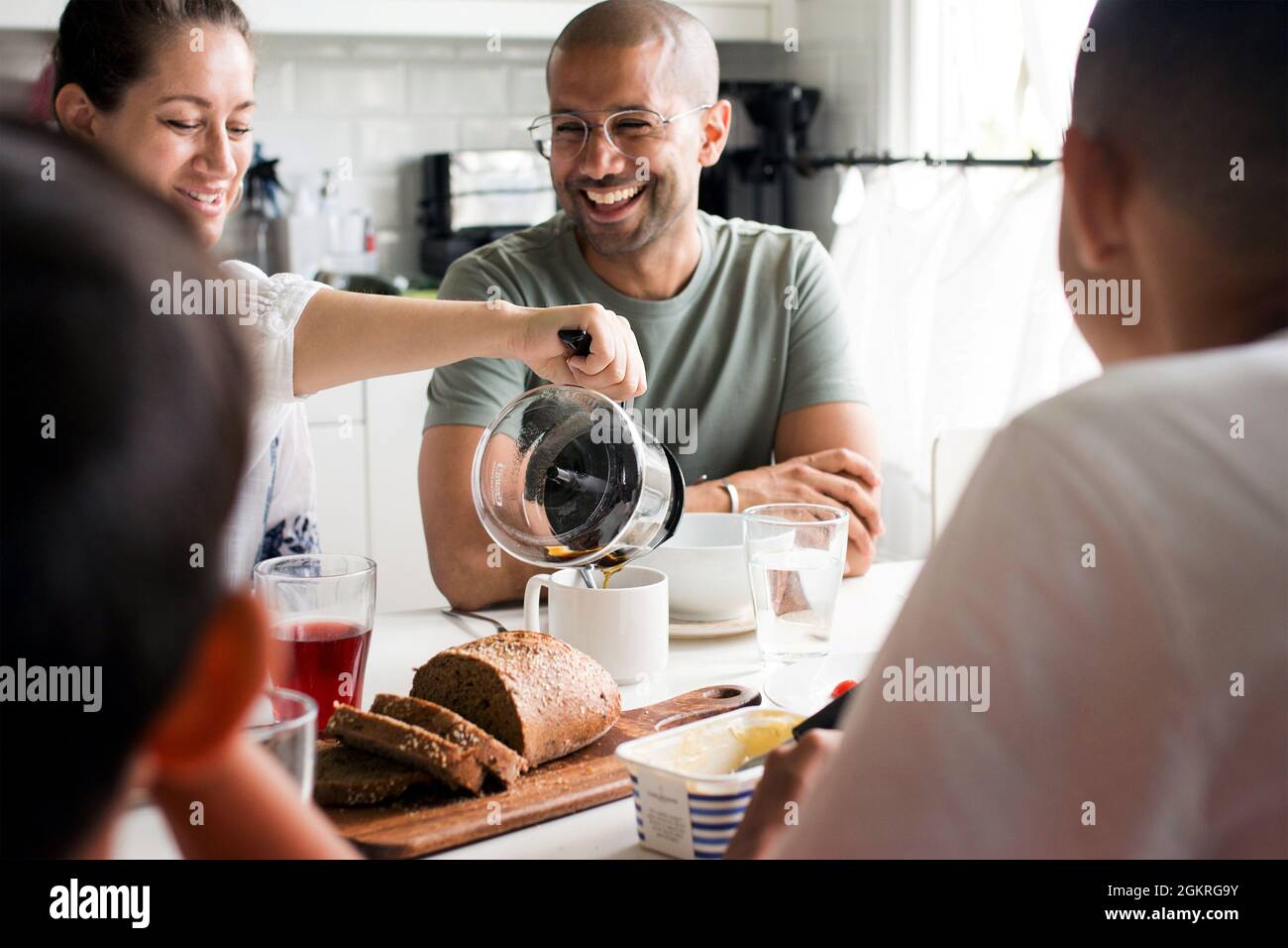 A family, mother and father, and two boys, brothers, eating breakfast ...