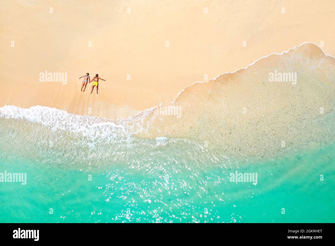 A couple lies on the beach of Mauritius in the Indian Ocean. Top view ...