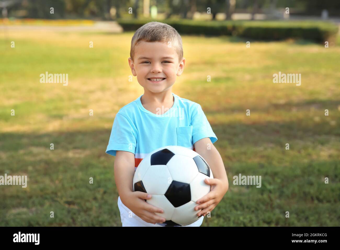 Cute little boy holding ball outdoors Stock Photo - Alamy