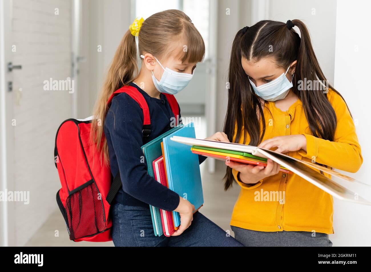 Cute little girls of primary hug each other with the mask on. School ...