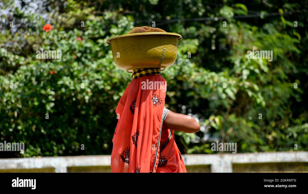Woman carrying an Indian traditional pot full of seeds on her head ...