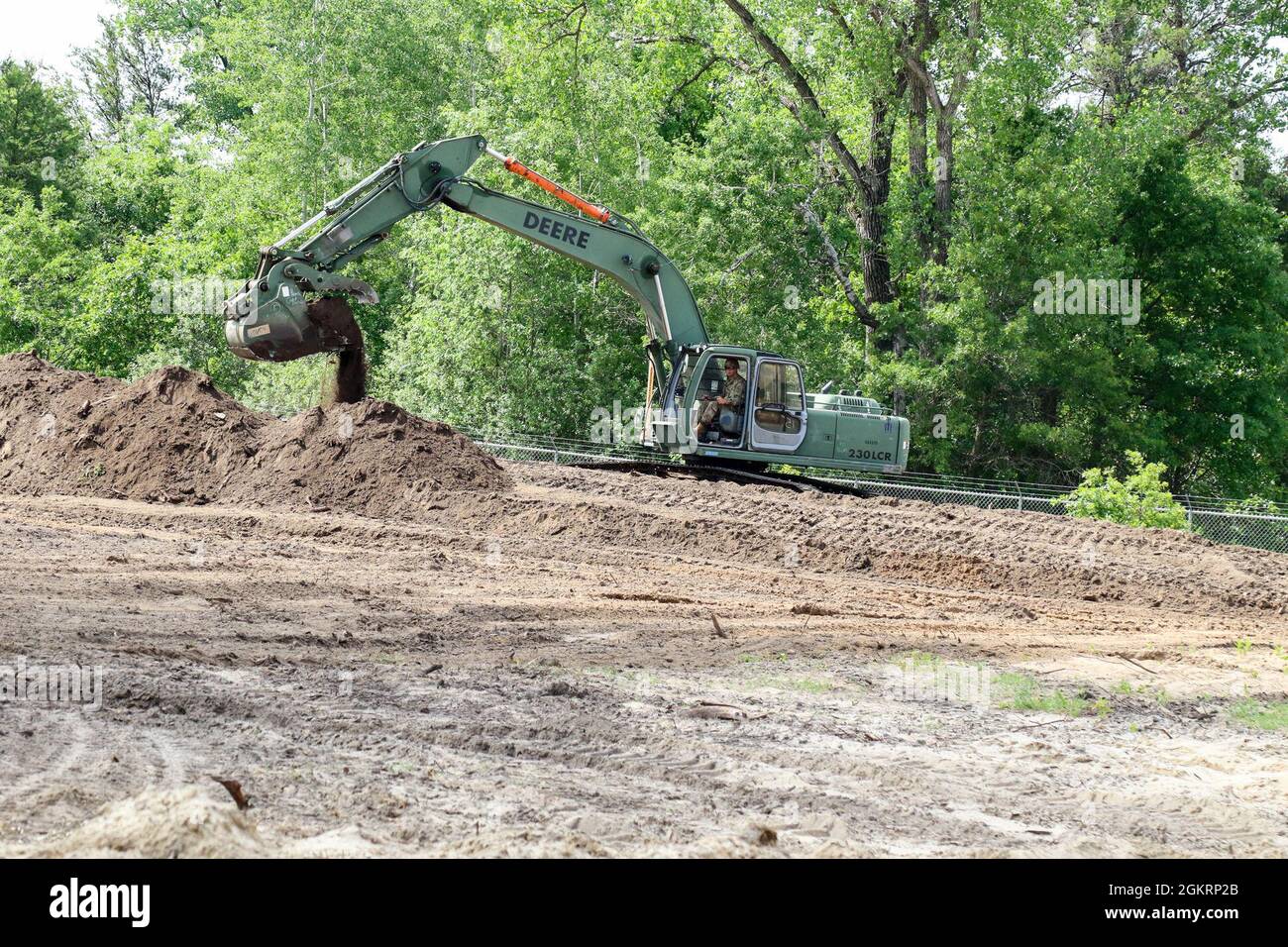 Army Reserve Spc. Ryan Hannegrafs, maneuvers an excavator to build a ...