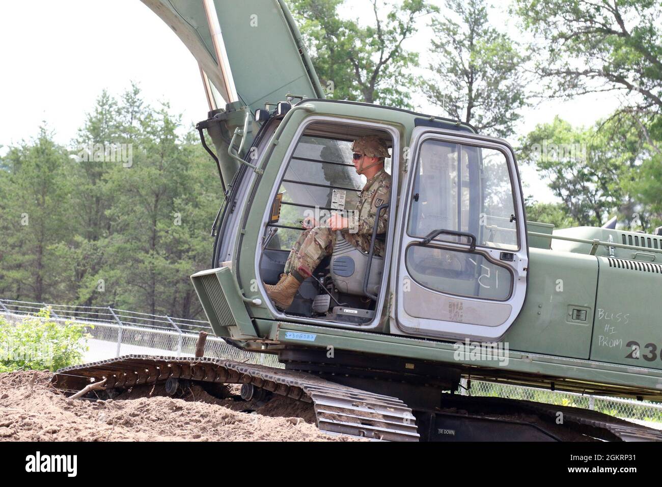 Army Reserve Spc. Ryan Hannegrafs, maneuvers an excavator to build a ...