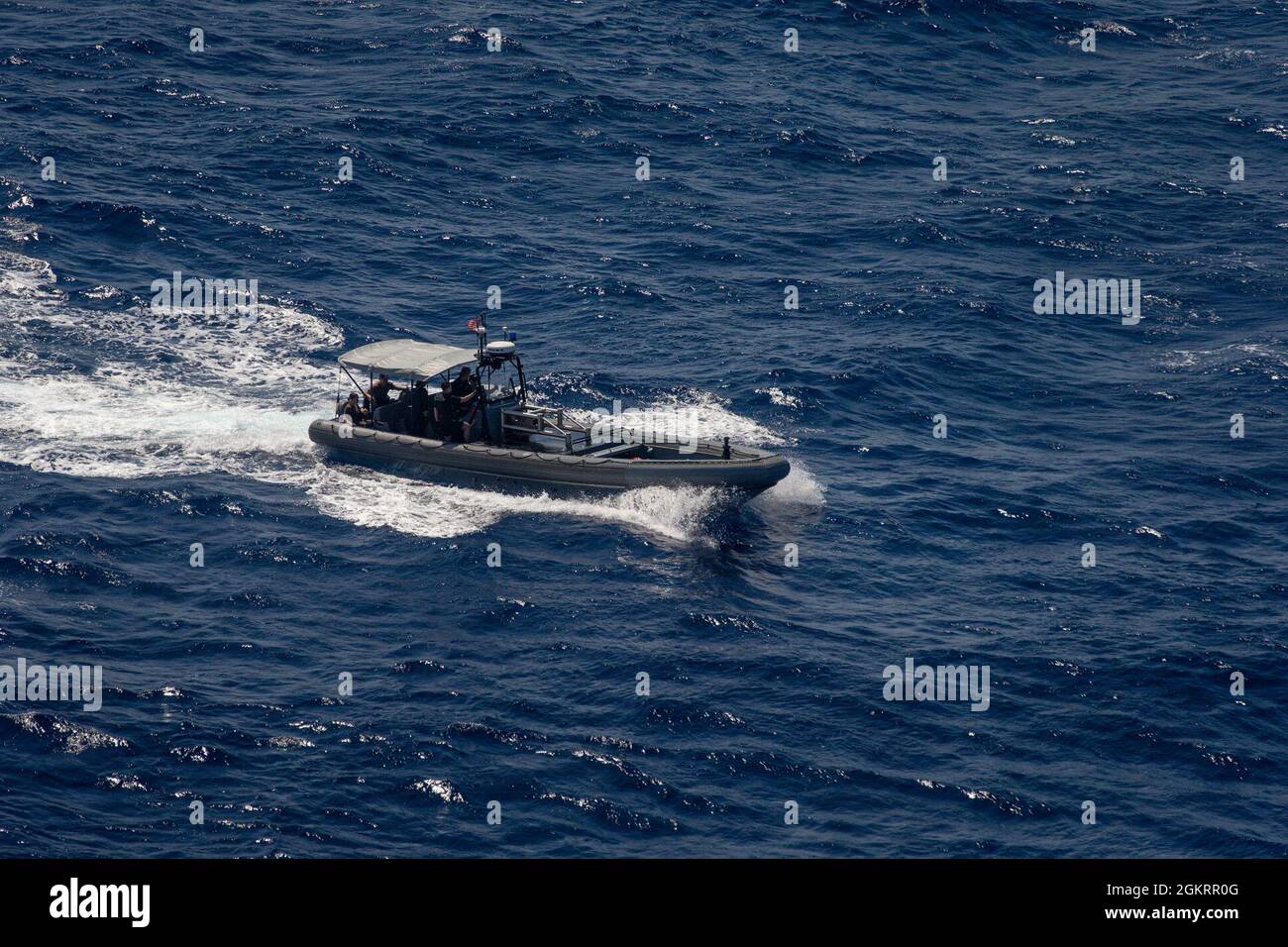 U.S. Navy sailors provide security in a rigid hull inflatable boat as ...