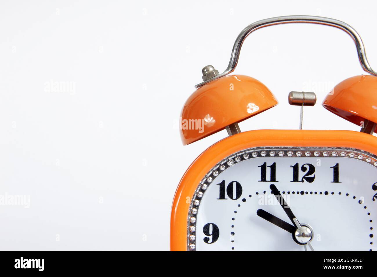Orange alarm clock on a white background Stock Photo - Alamy