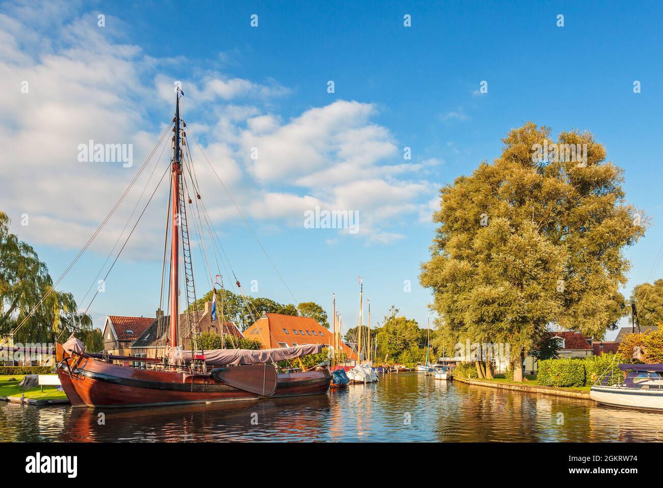 Old wooden sailing boat in a canal in the Dutch village Heeg, Friesland ...