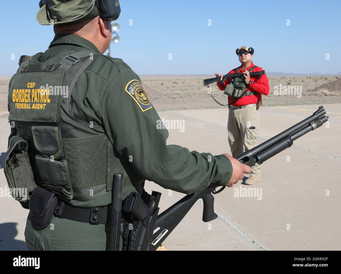 A Border Patrol agent keeps his tactical shotgun muzzle pointed ...