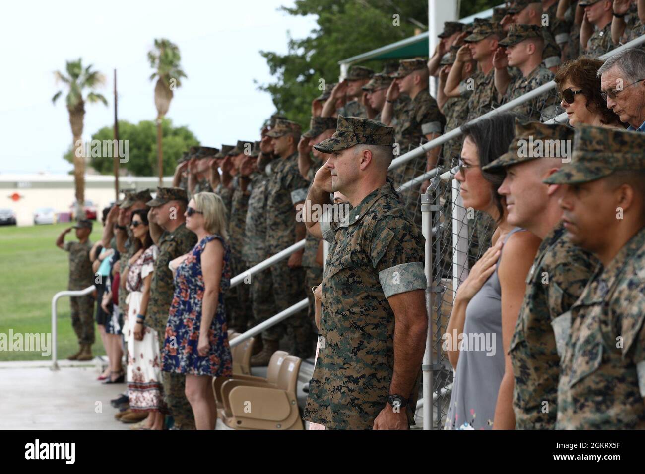 U.S. Marines, Sailors, and guests stand for the national anthem during ...