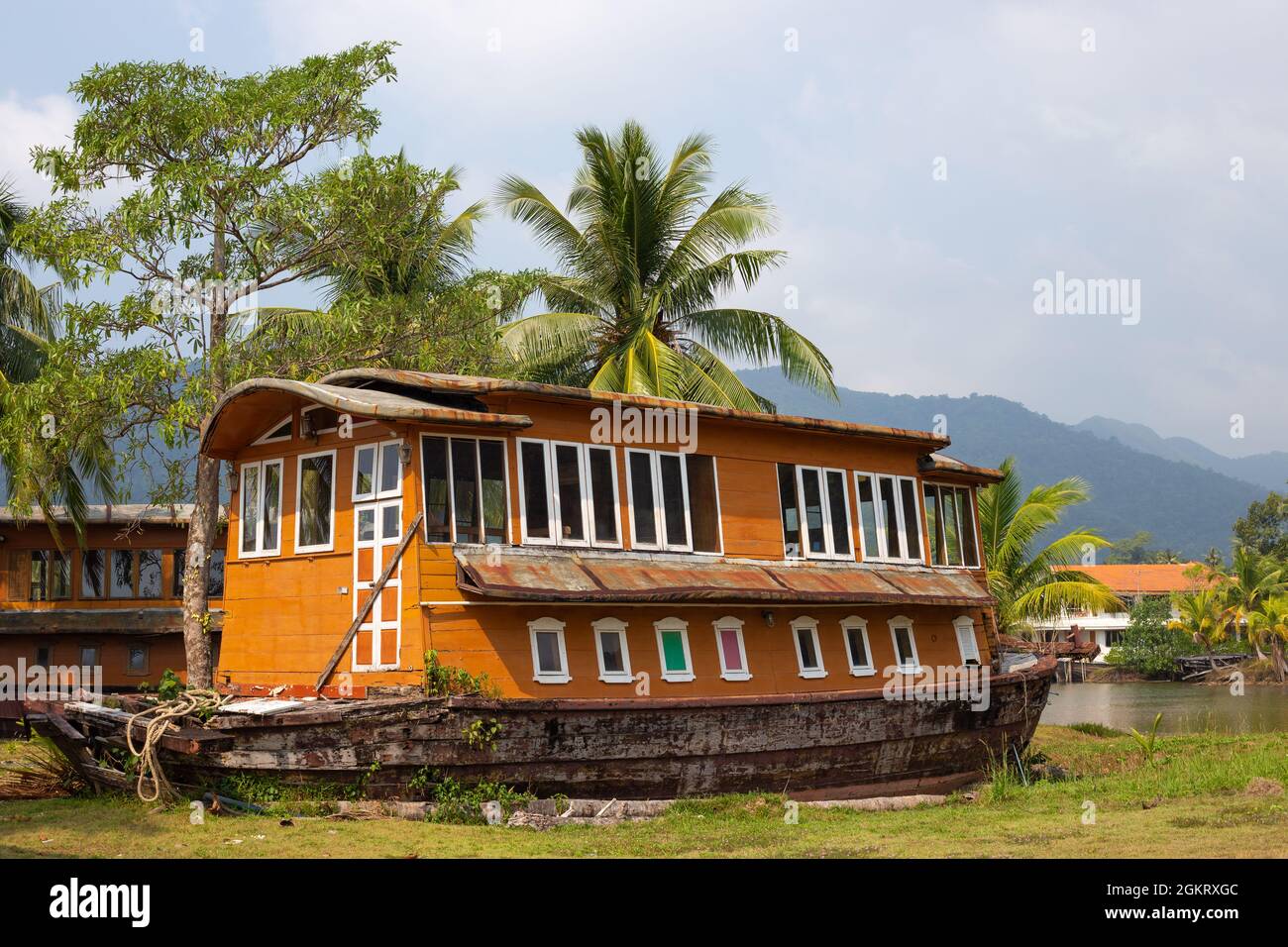 a ship-shaped hotel in the tropics among coconut trees and mountains ...