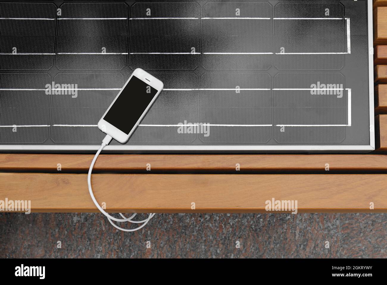 Mobile phone charging on bench with solar panel Stock Photo - Alamy