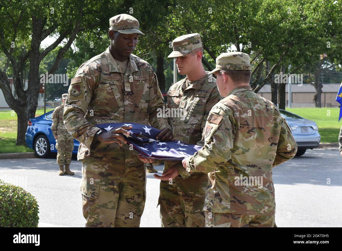 Staff Sgt. Marquis Fludd, left,461st Air Control Wing, folds a U.S ...